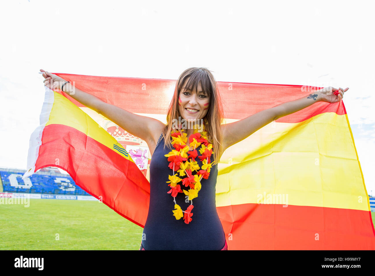 Young woman with face paint holding Spanish flag Stock Photo - Alamy