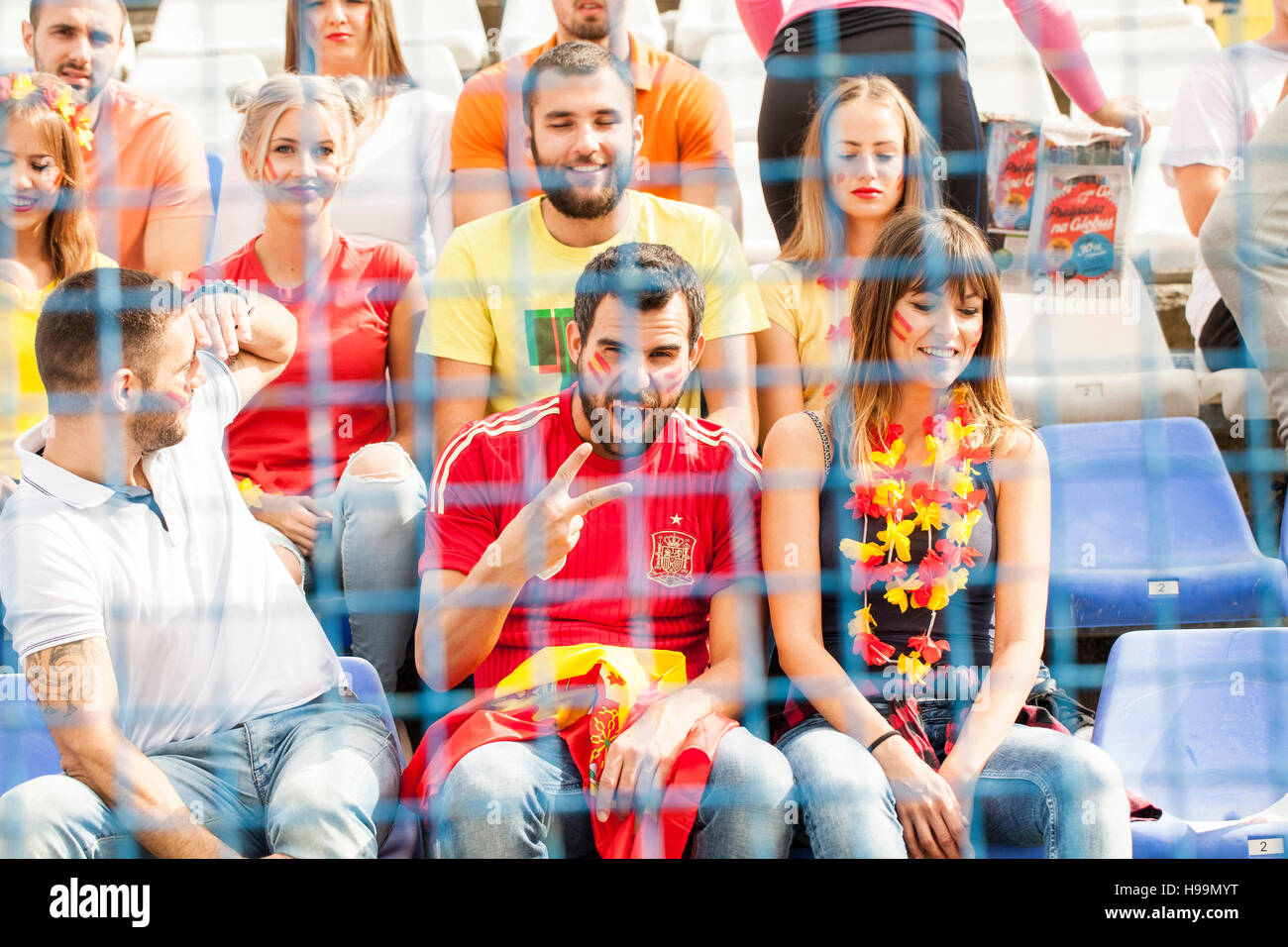 Group of soccer fans behind fence in stadium Stock Photo - Alamy