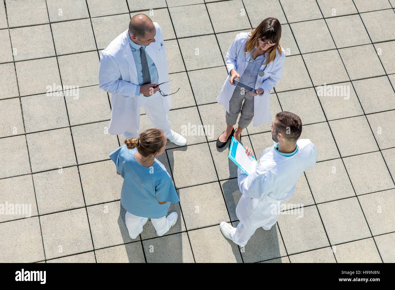 Doctors stand in circle talking Stock Photo - Alamy