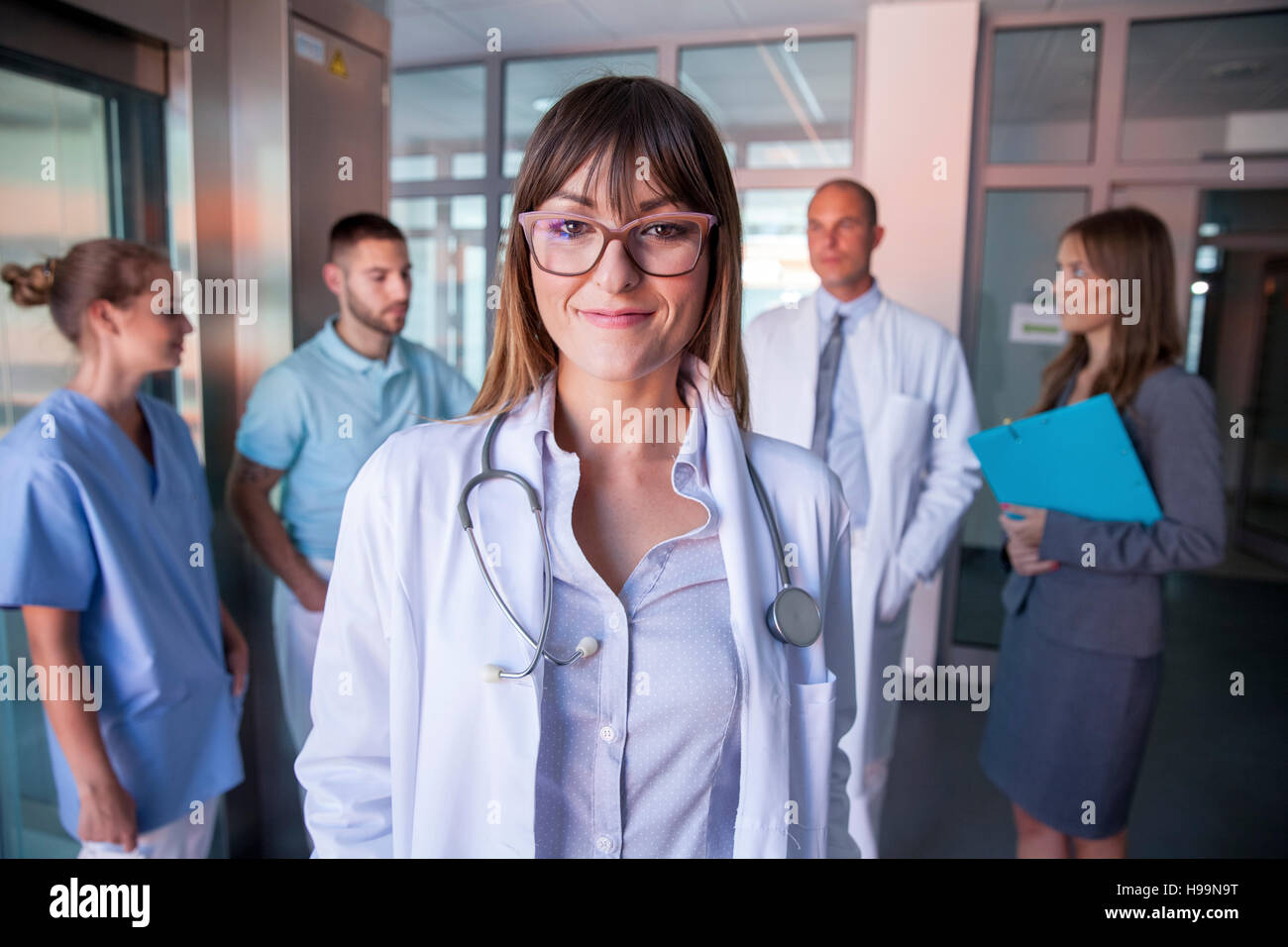 Female doctor standing in front of her team Stock Photo - Alamy