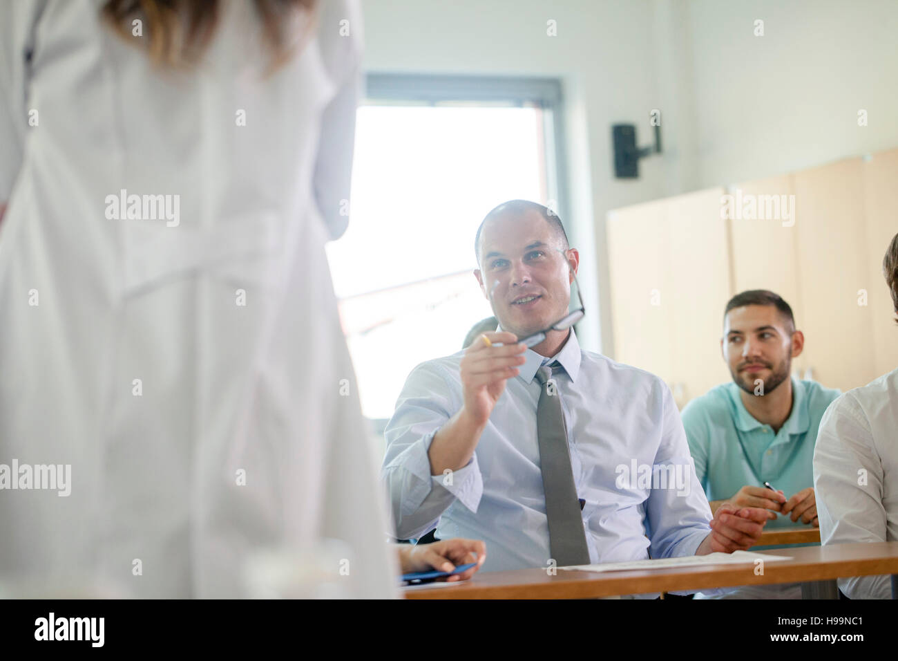 Businessman and instructor discussing in training class Stock Photo - Alamy