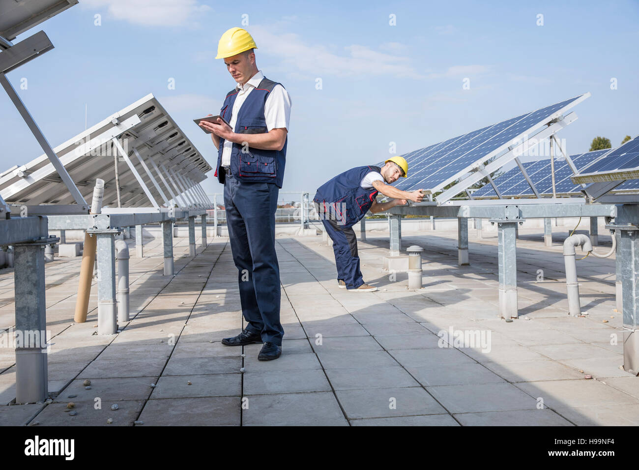 Construction workers checking solar panel structures Stock Photo - Alamy
