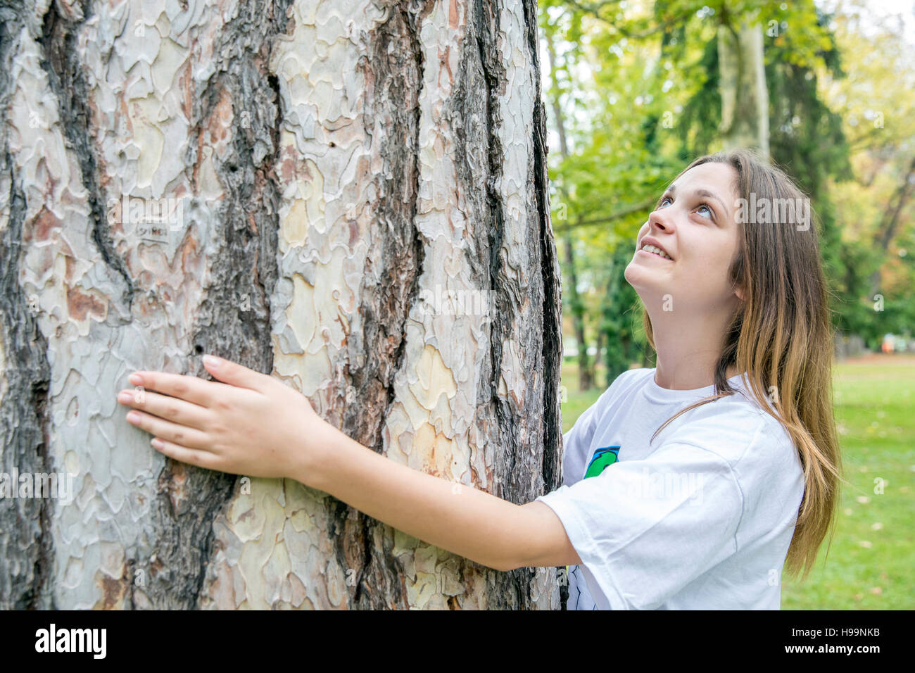 Teenage environmentalist hugging tree Stock Photo - Alamy