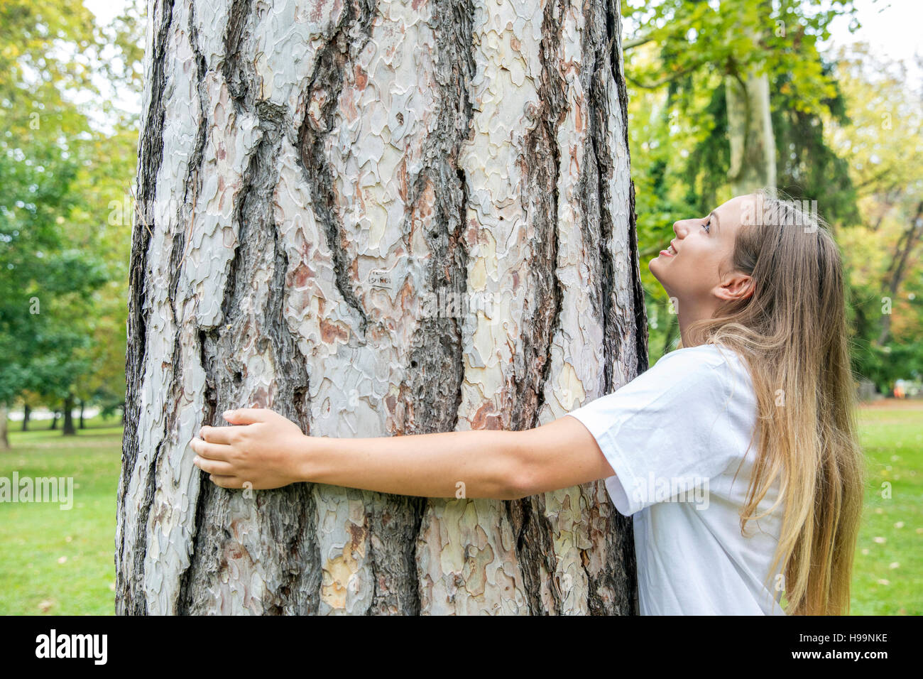Teenage environmentalist hugging tree Stock Photo - Alamy