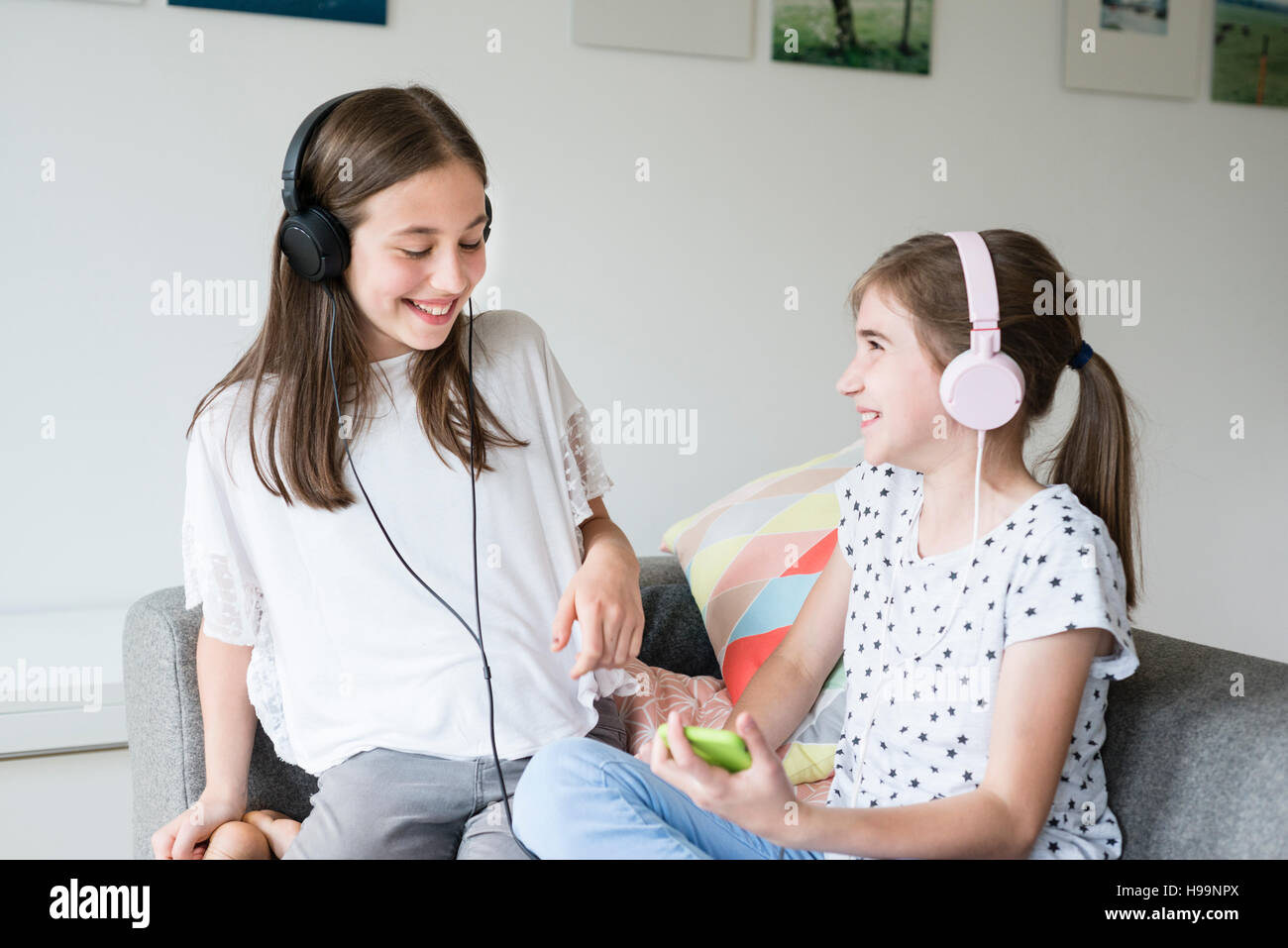Two teenage girls with headphones listening to music Stock Photo - Alamy
