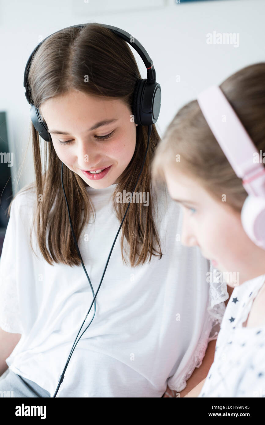 Two teenage girls with headphones listening to music Stock Photo - Alamy