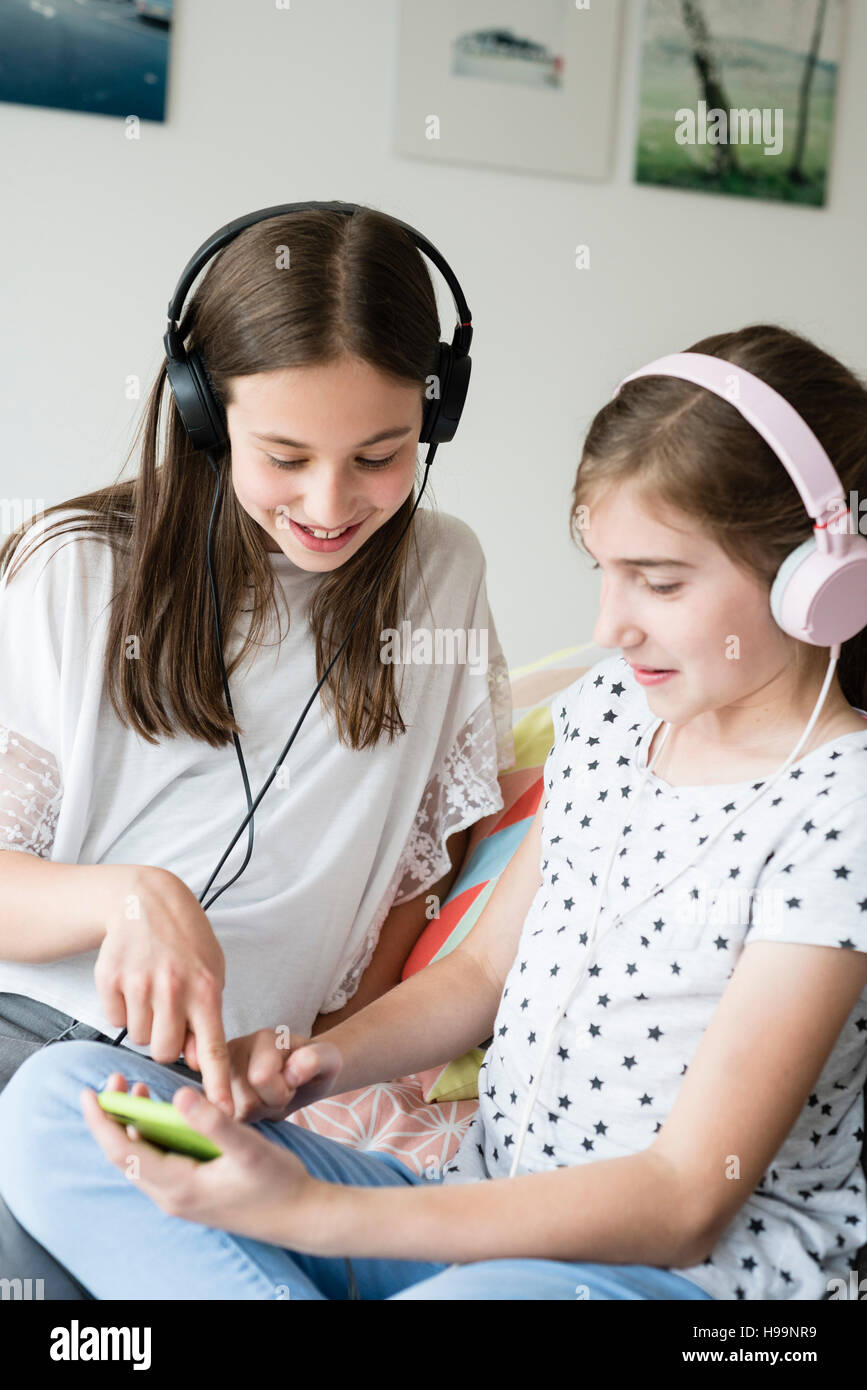 Two teenage girls listening to mp3 player hi-res stock photography and ...