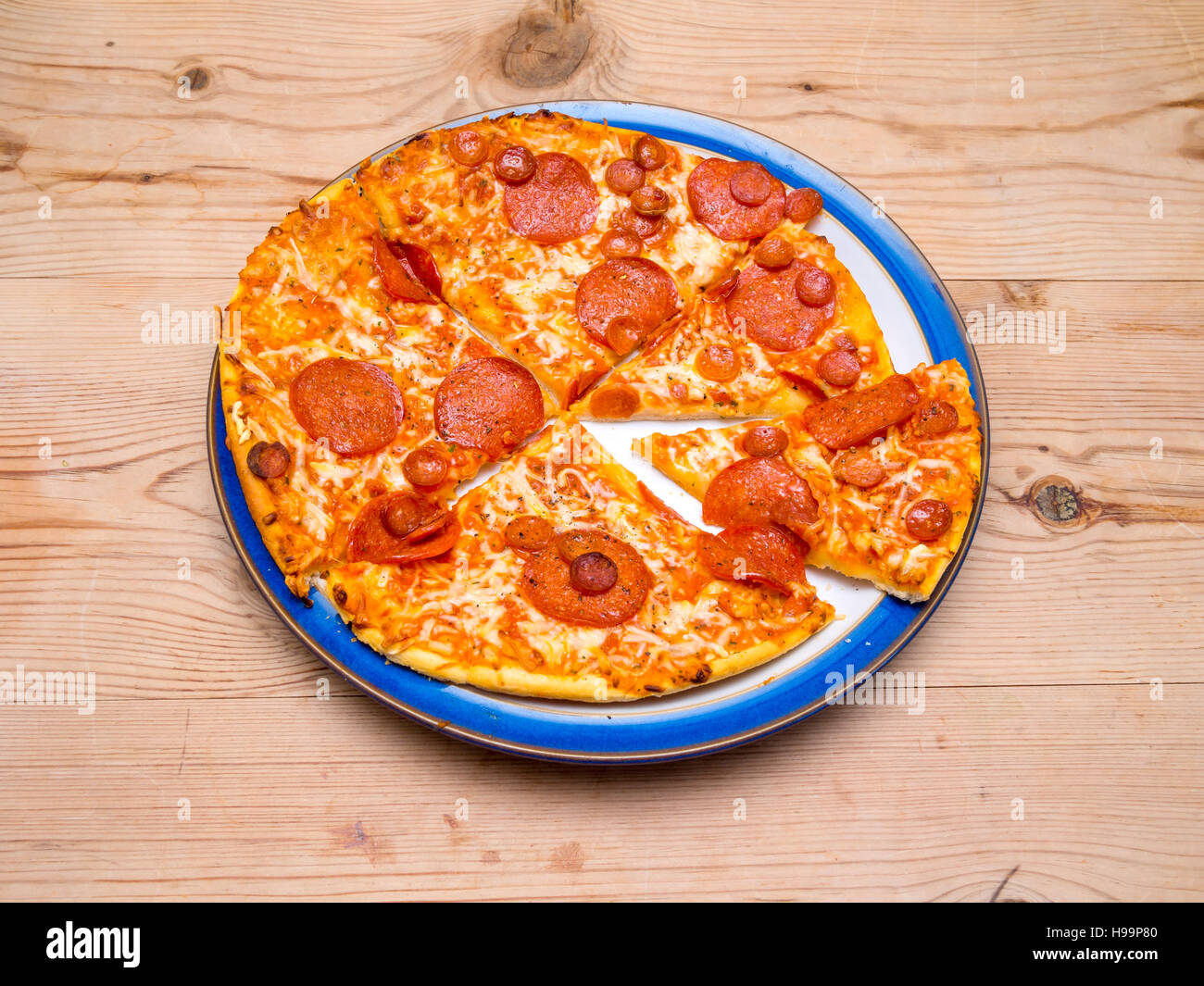 Classic American Pizza Pepperoni and Salami on a white plate with blue ...