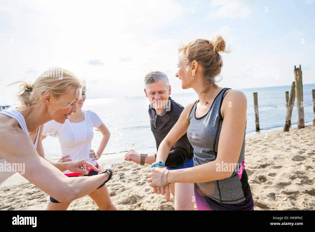 Group of friends checking their running watches Stock Photo - Alamy
