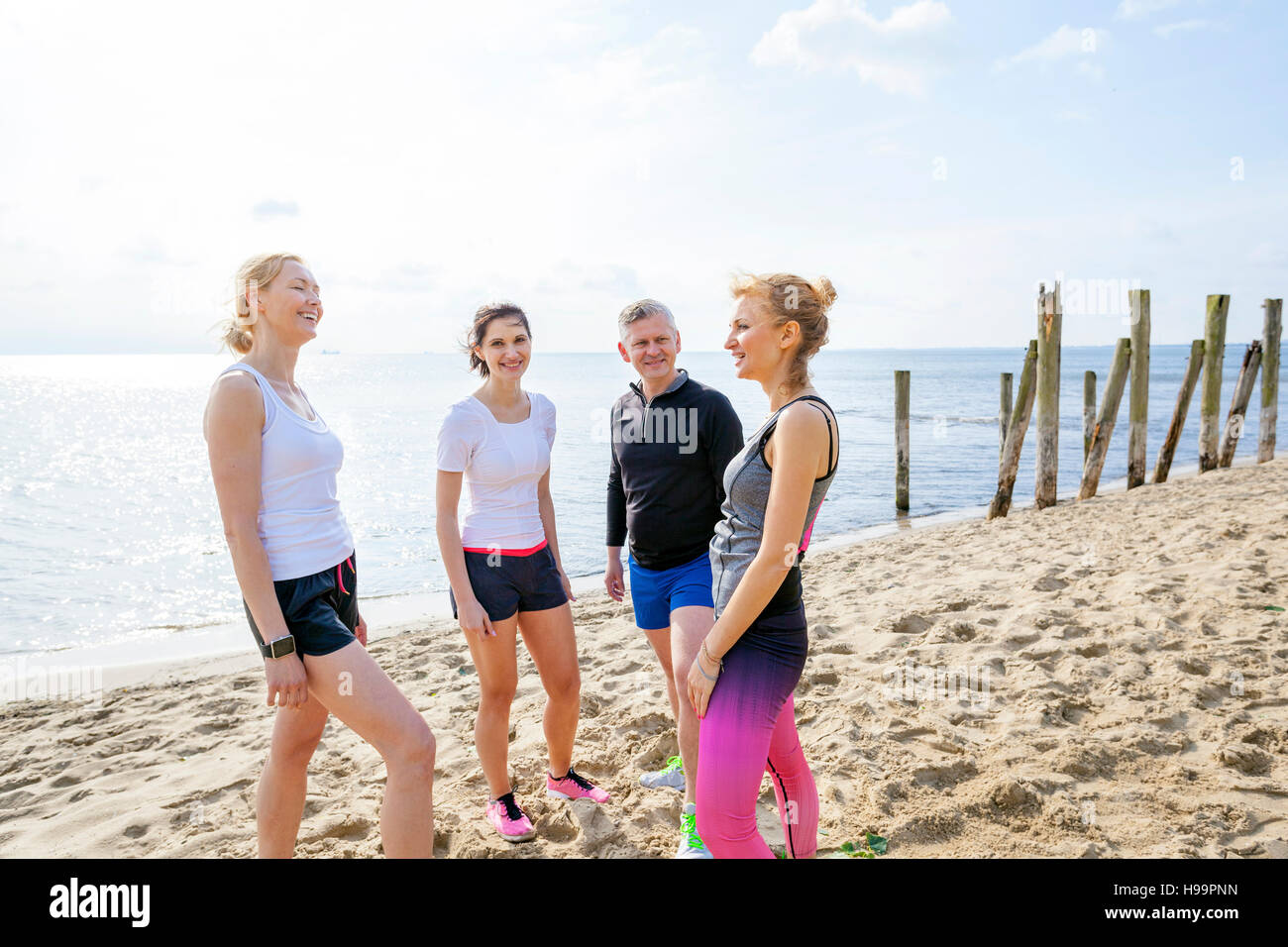 Group of runners on beach taking a break Stock Photo - Alamy