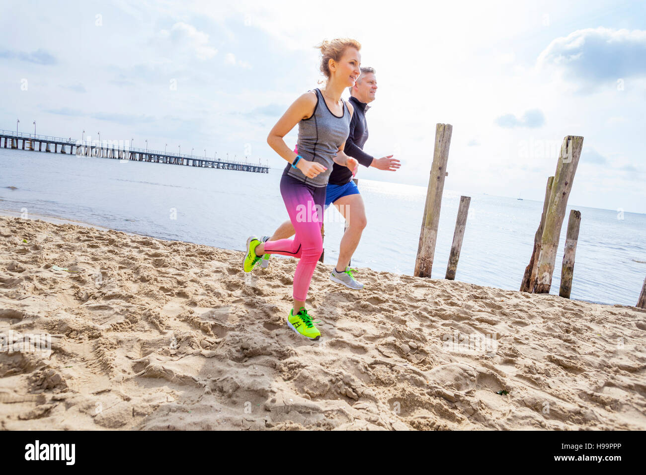 Two women jogging along beach hi-res stock photography and images - Alamy