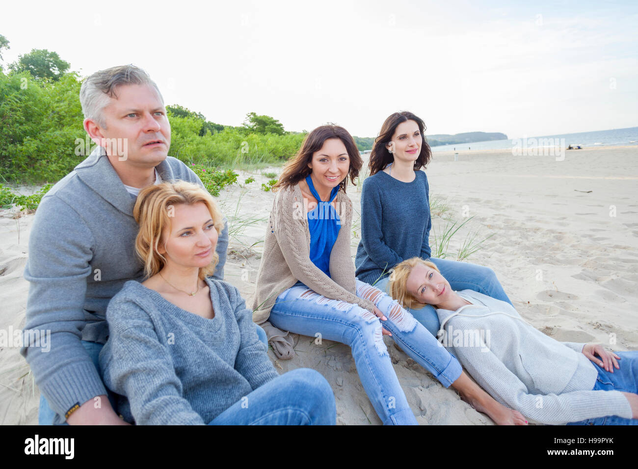 Group of friends on beach relaxing Stock Photo - Alamy