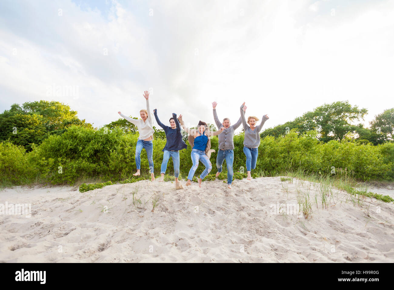 Group of women cheering on sandy beach Stock Photo - Alamy