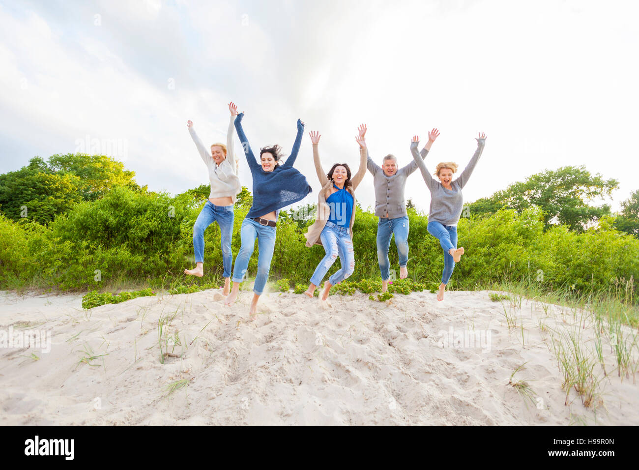 Group of women cheering on sandy beach Stock Photo - Alamy