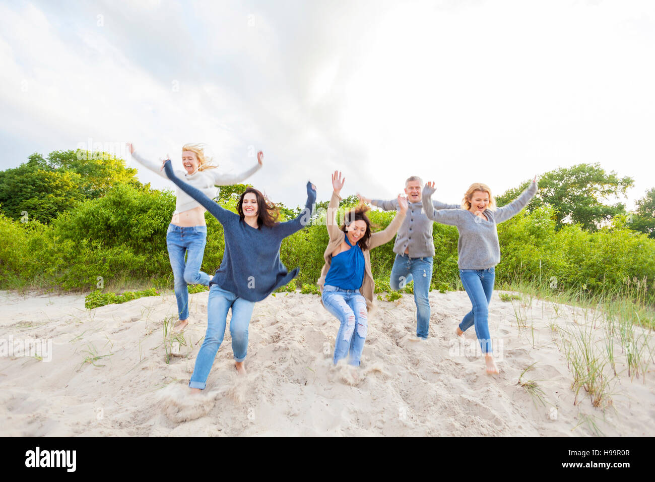 Group of women cheering on sandy beach Stock Photo - Alamy