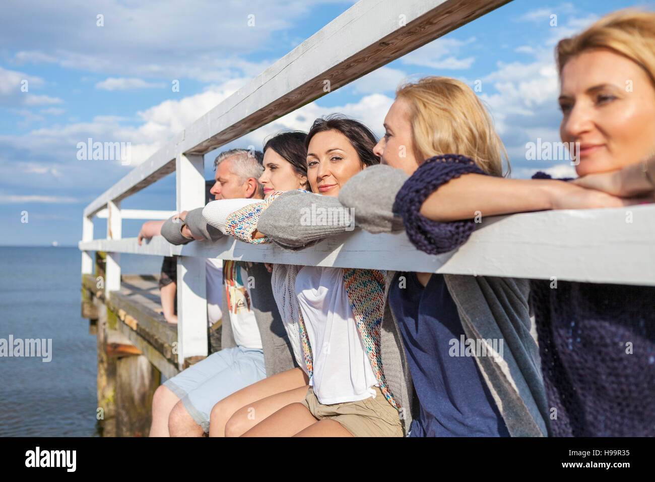 Group of friends relaxing on jetty Stock Photo - Alamy