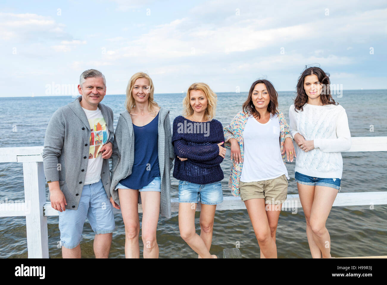 Group of friends relaxing on jetty Stock Photo - Alamy
