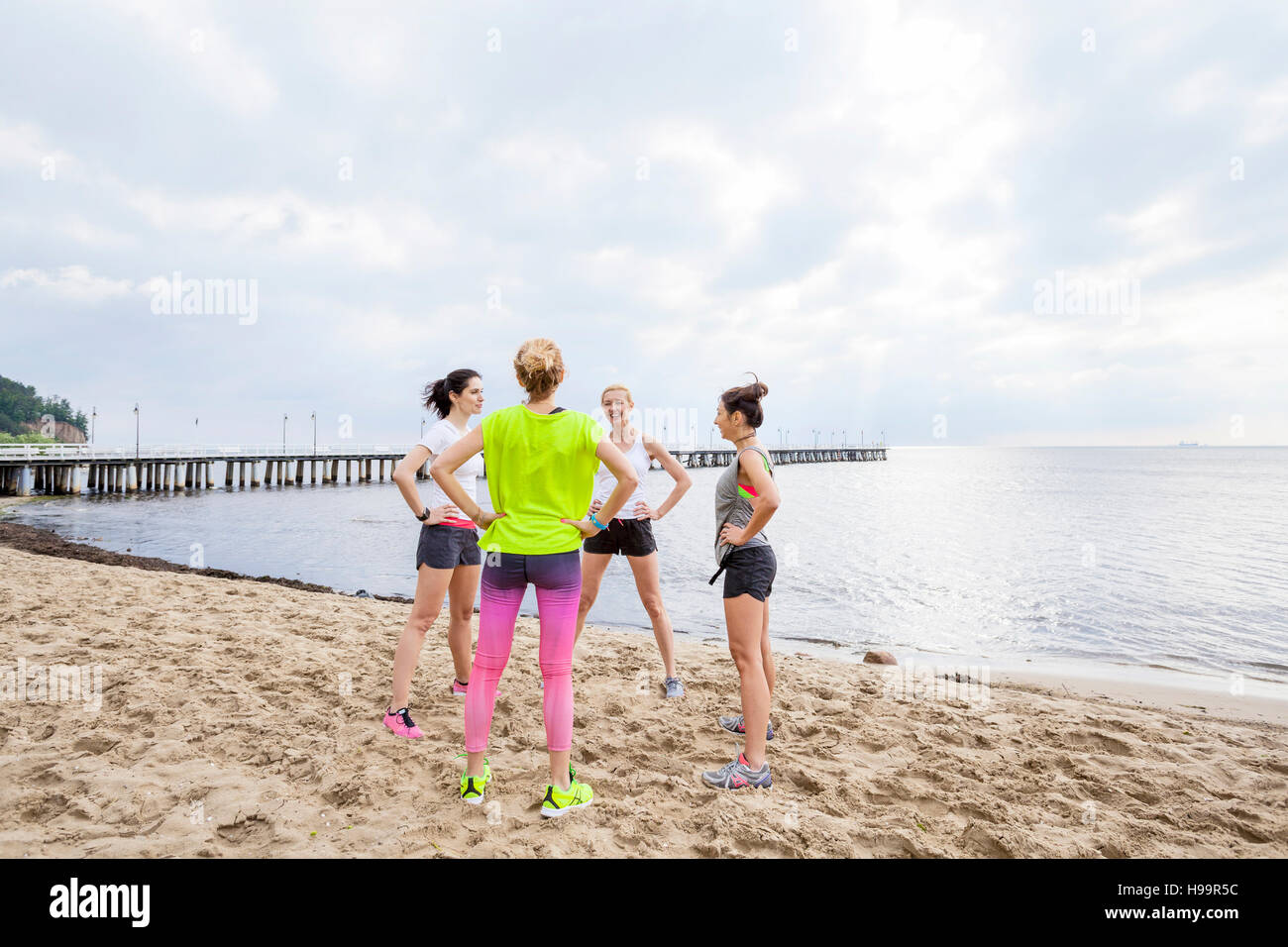 Group of women on beach doing warm up exercises Stock Photo - Alamy