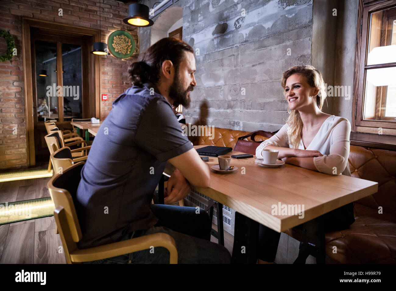 Couple in coffee shop having a conversation Stock Photo - Alamy