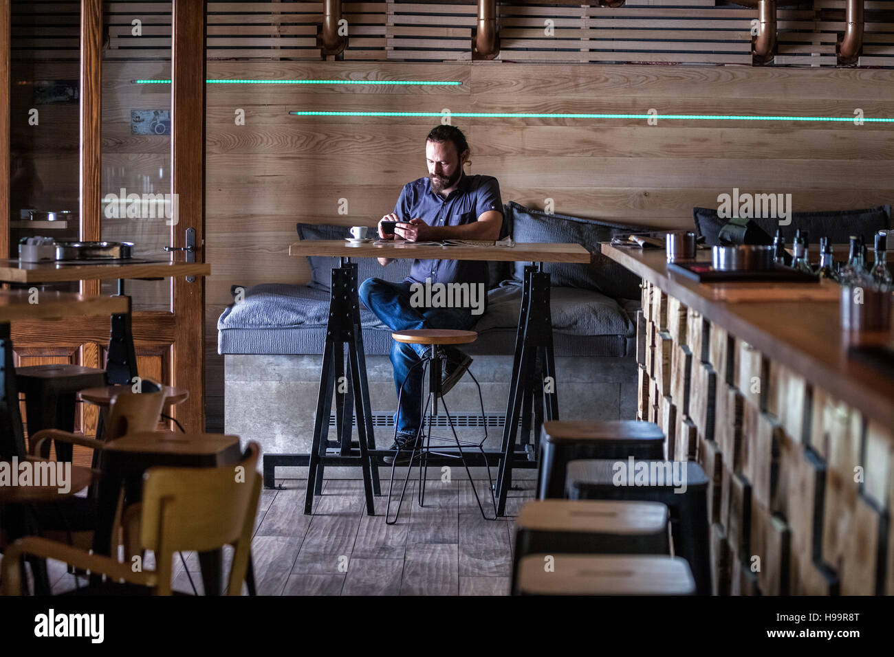 Man in coffee shop using smart phone Stock Photo - Alamy