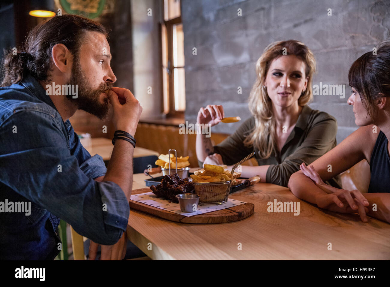 Group of friends eating snacks in coffee shop Stock Photo - Alamy