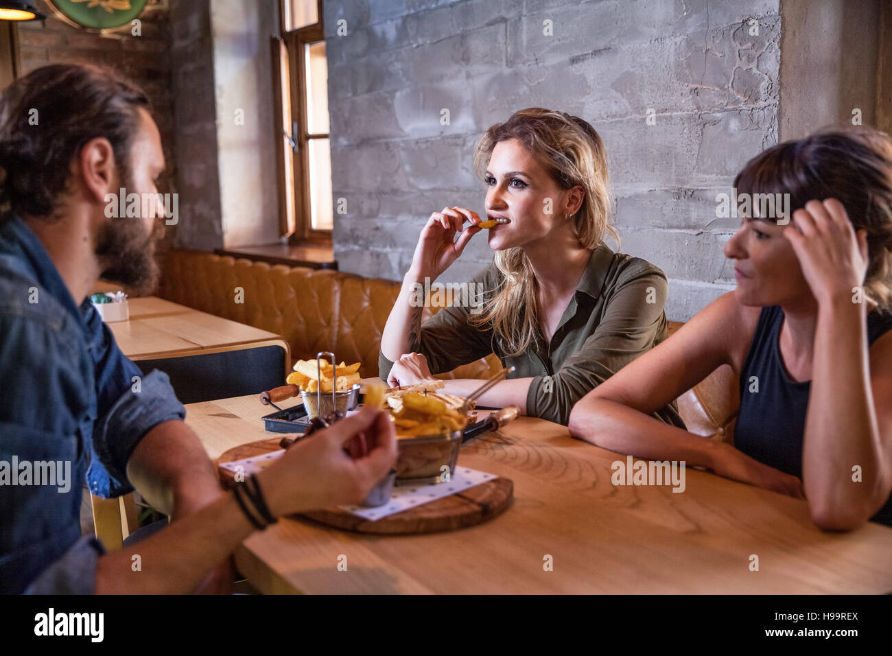 Group of friends eating snacks in coffee shop Stock Photo - Alamy