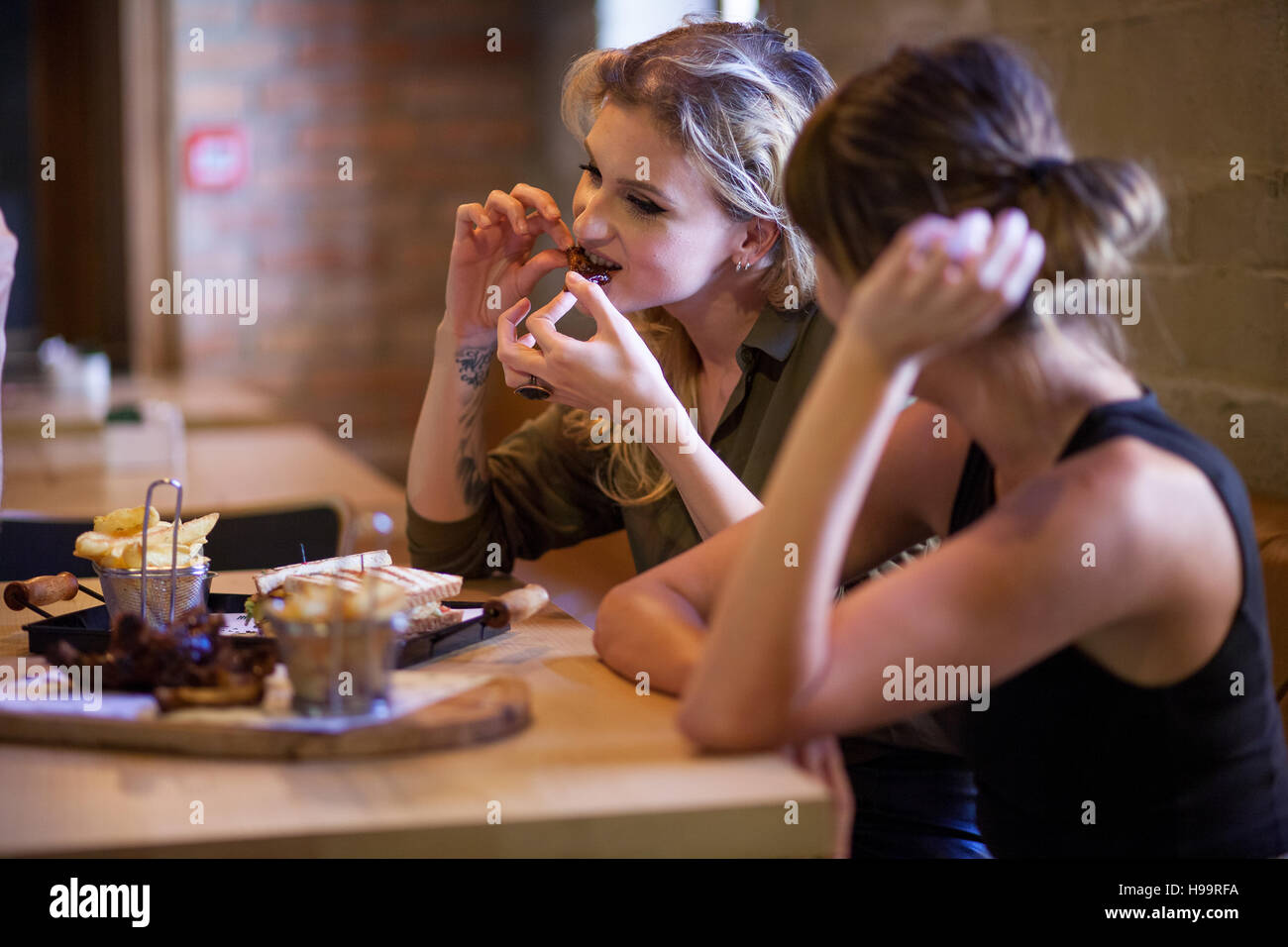 Group of friends eating snacks in coffee shop Stock Photo - Alamy