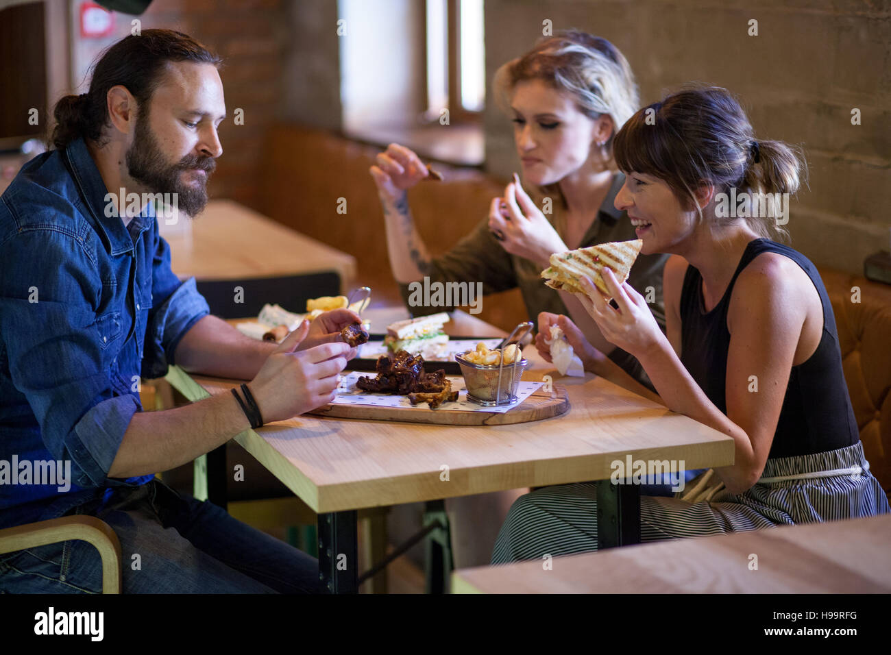 Group of friends eating snacks in coffee shop Stock Photo - Alamy