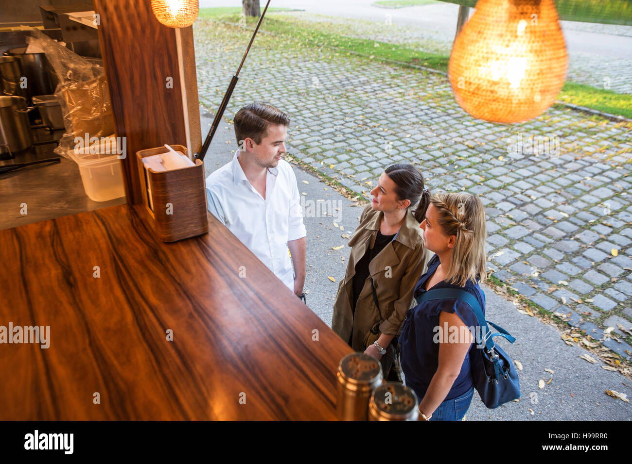 Customers waiting in front of counter of food truck Stock Photo - Alamy