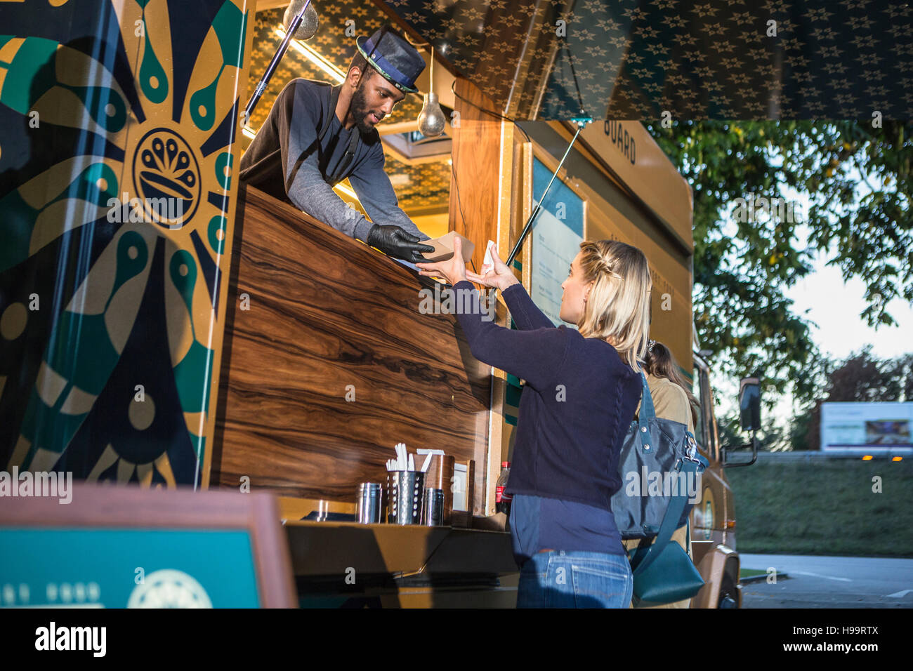 Customer receiving food from vendor at food truck Stock Photo - Alamy