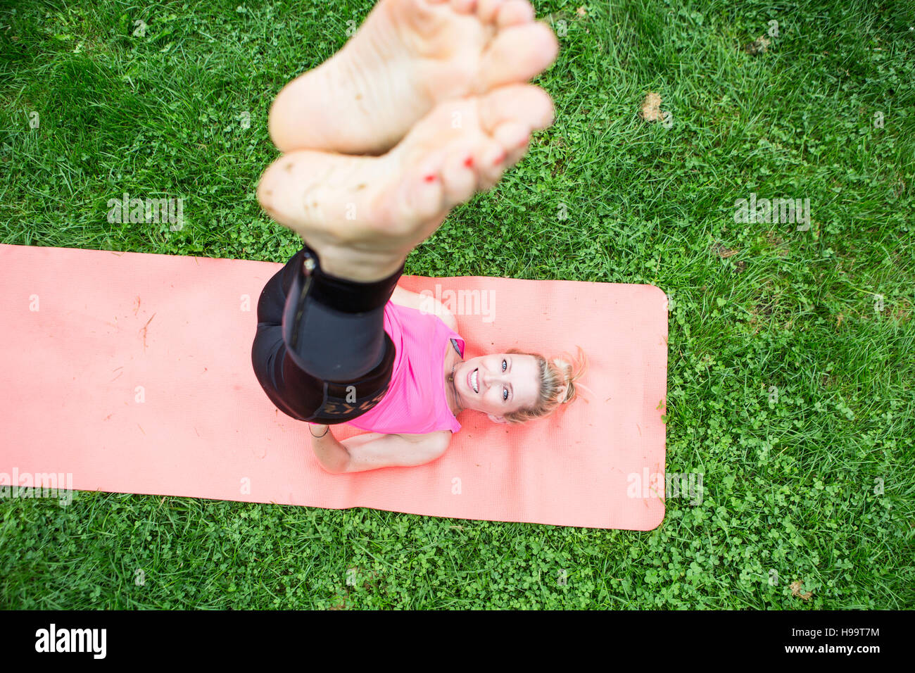 Young woman practicing yoga legs in the air Stock Photo - Alamy
