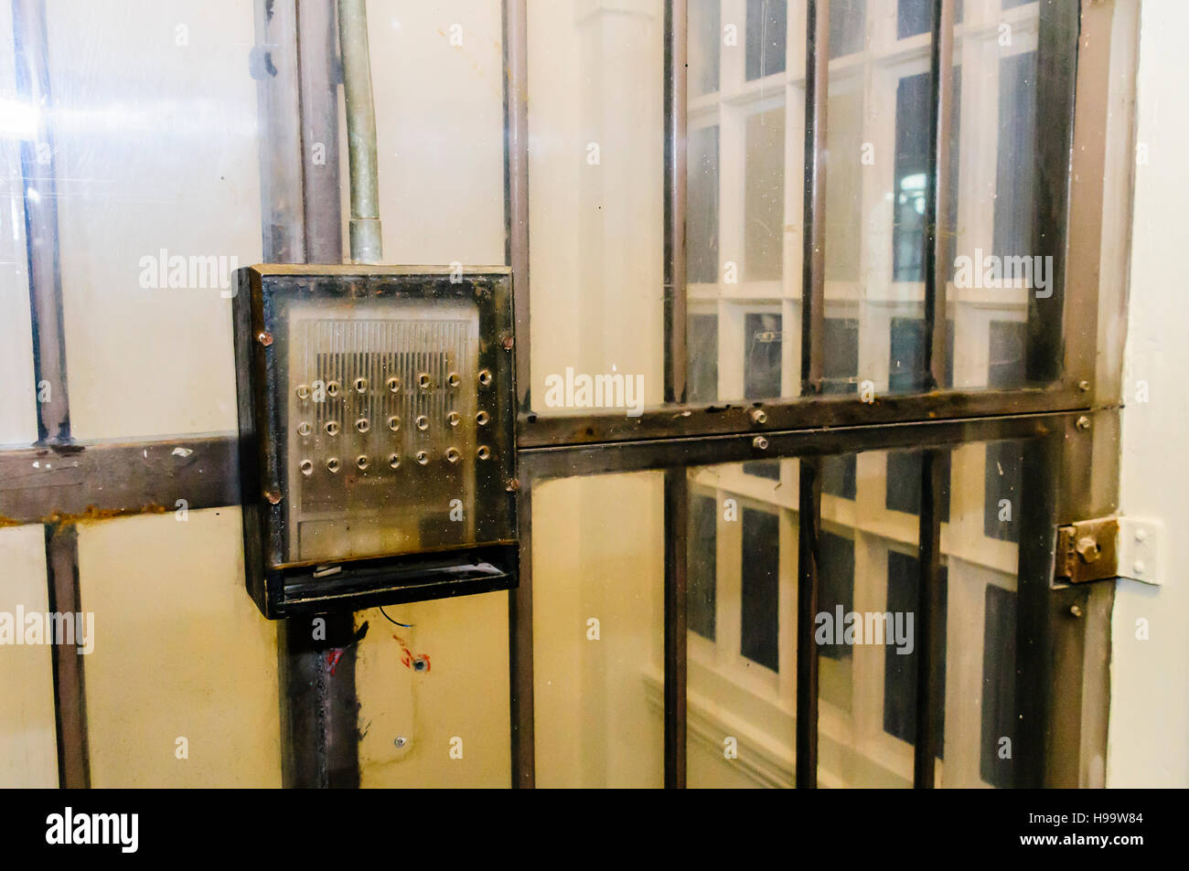 Intercom and steel barred doors in a prison, covered with toughened ...