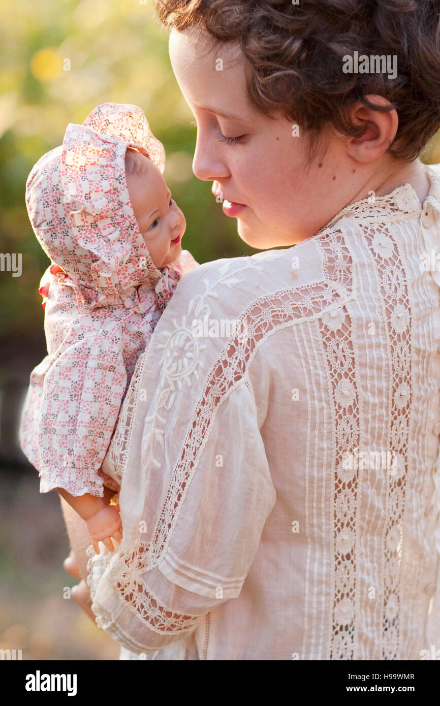 Young girl holding her doll outdoors Stock Photo - Alamy Young girl holding her doll outdoors Stock Photo - Alamy