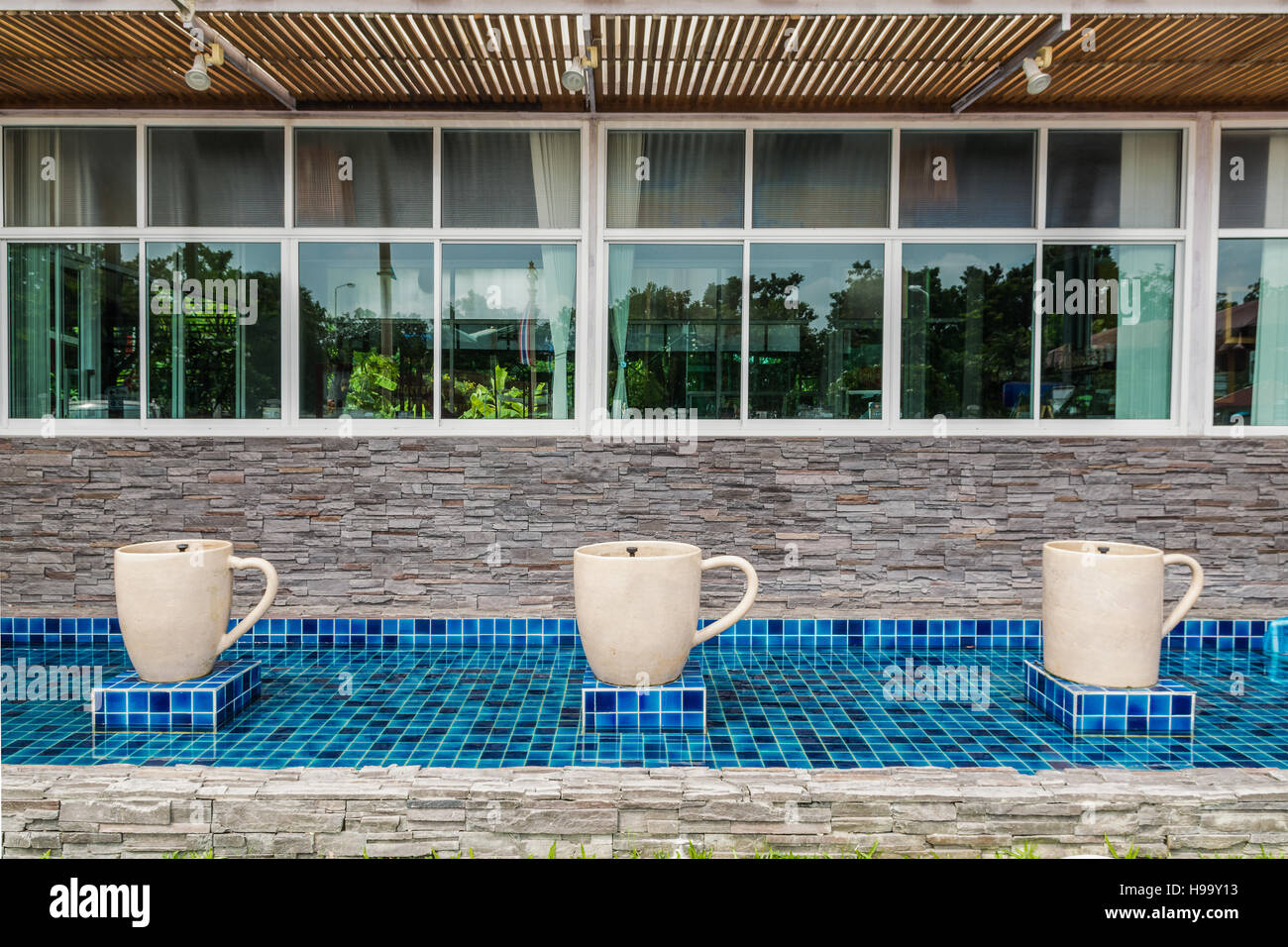 Pond in front garden with a statue cup of coffee Stock Photo - Alamy