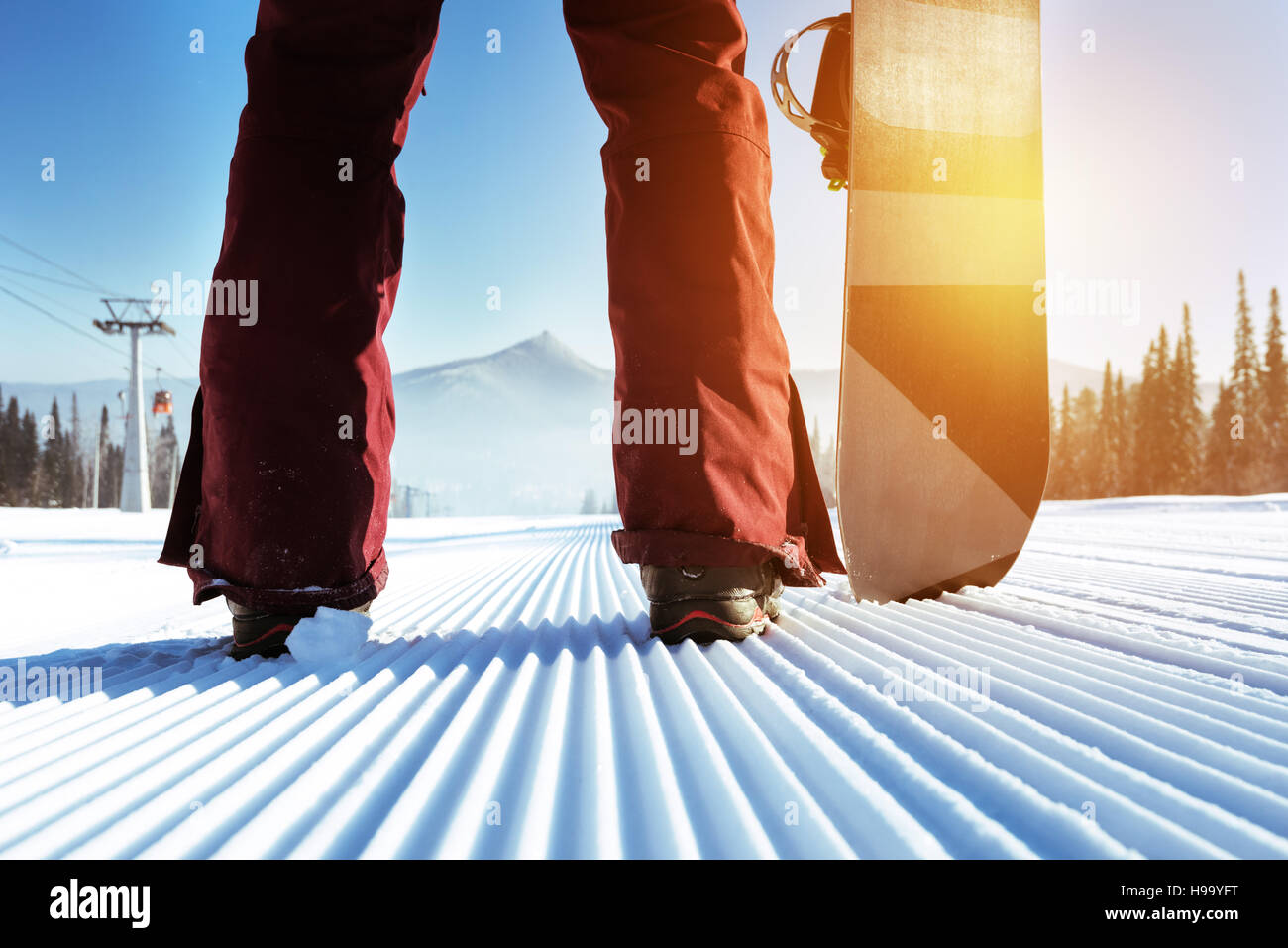 Snowboarder stands on slope backdrop Stock Photo - Alamy