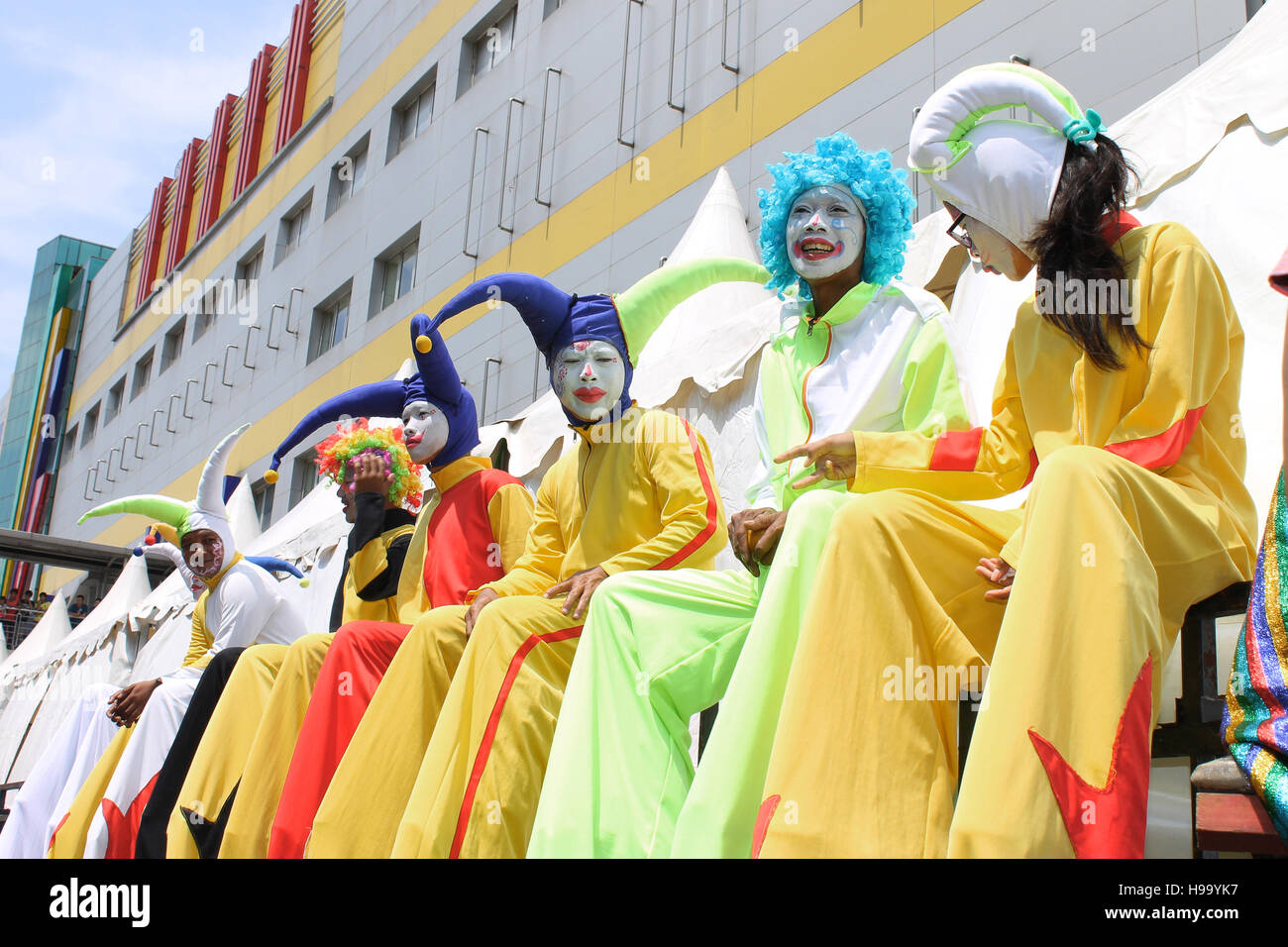 Long leg clowns have talking each other when waiting to perform in Cap ...