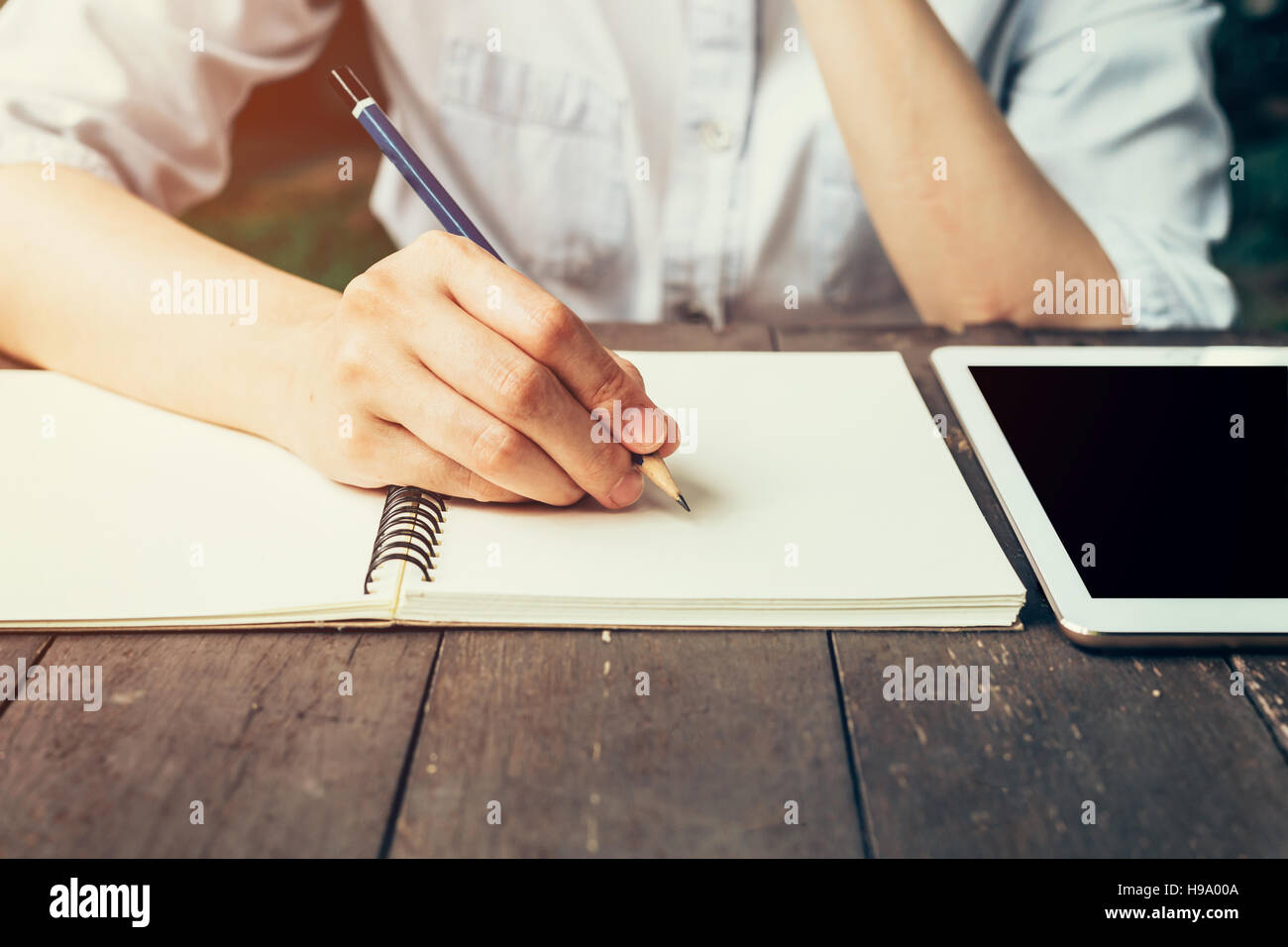 Female hand with pencil writing on notebook. Woman hand with pencil ...