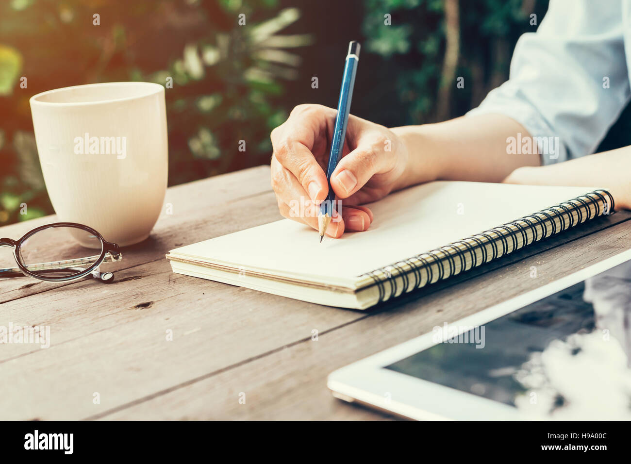 Female hand with pencil writing on notebook. Woman hand with pencil ...
