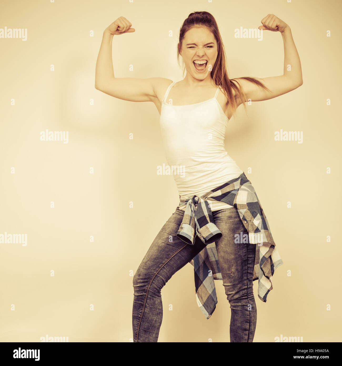 Strong woman showing off muscles. Young happy girl smiling. Power and ...
