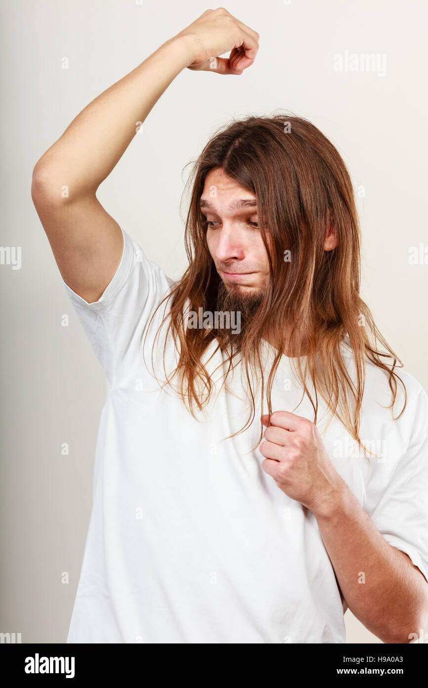 Expression of very bad smell. Young long haired sweaty man making hand ...