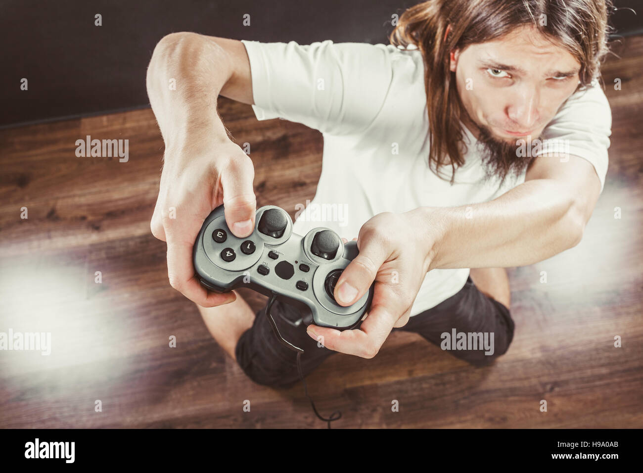 Addiction. Stressed depressed young man playing gaming on pad. Angry ...