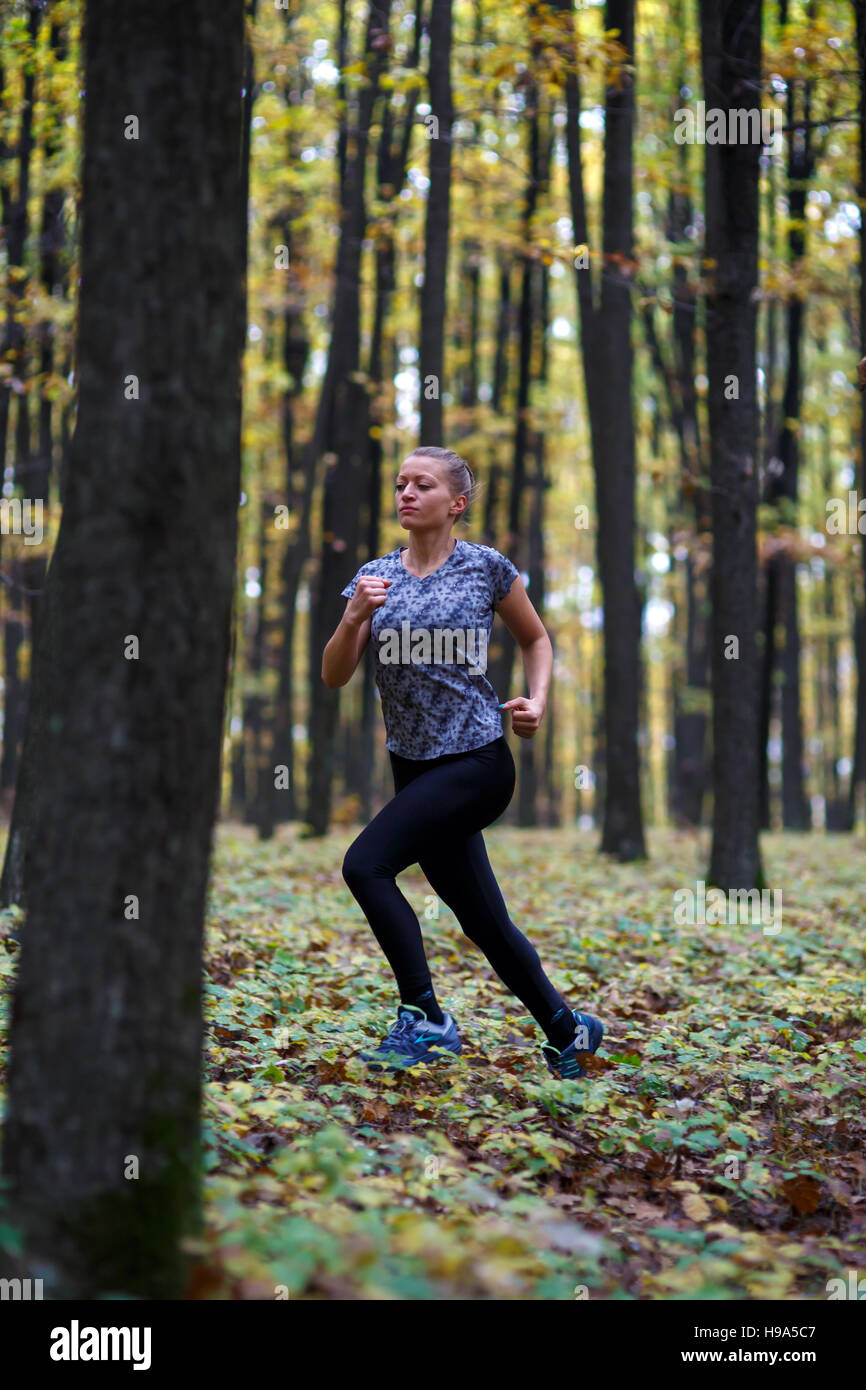 Woman trail running through forest hi-res stock photography and images ...