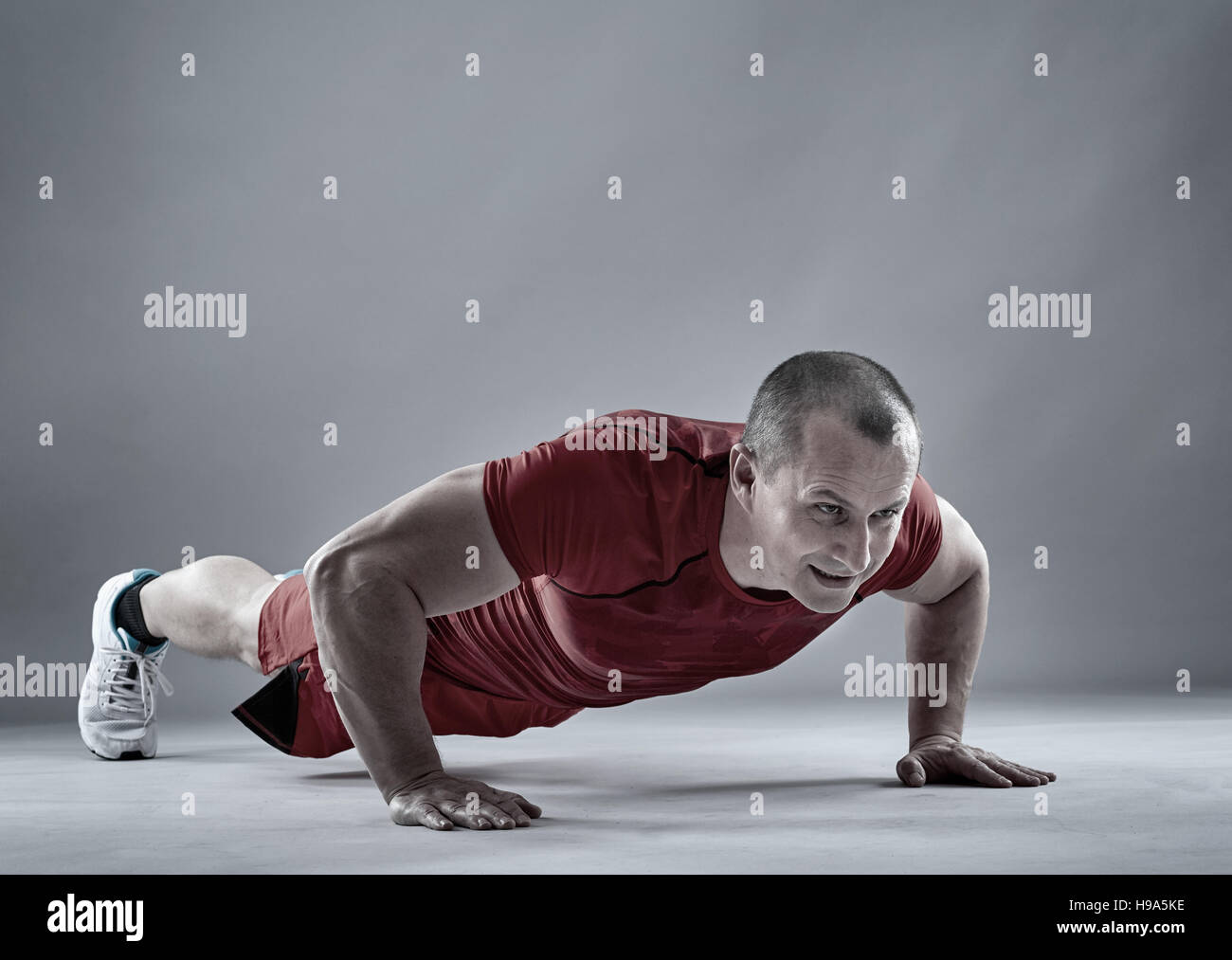 Fitness man doing pushups on gray background Stock Photo - Alamy
