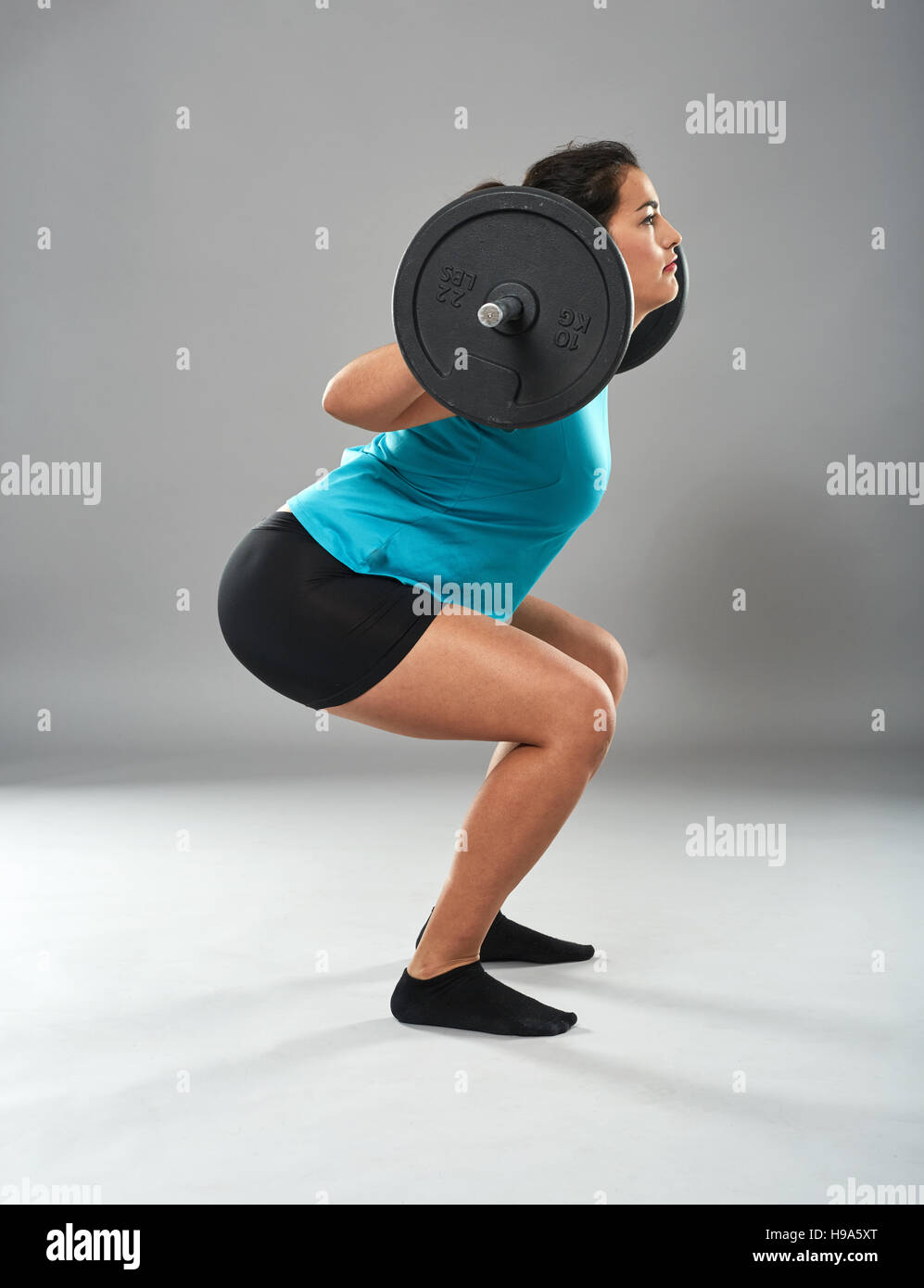 Very strong hispanic woman doing barbell squats Stock Photo - Alamy