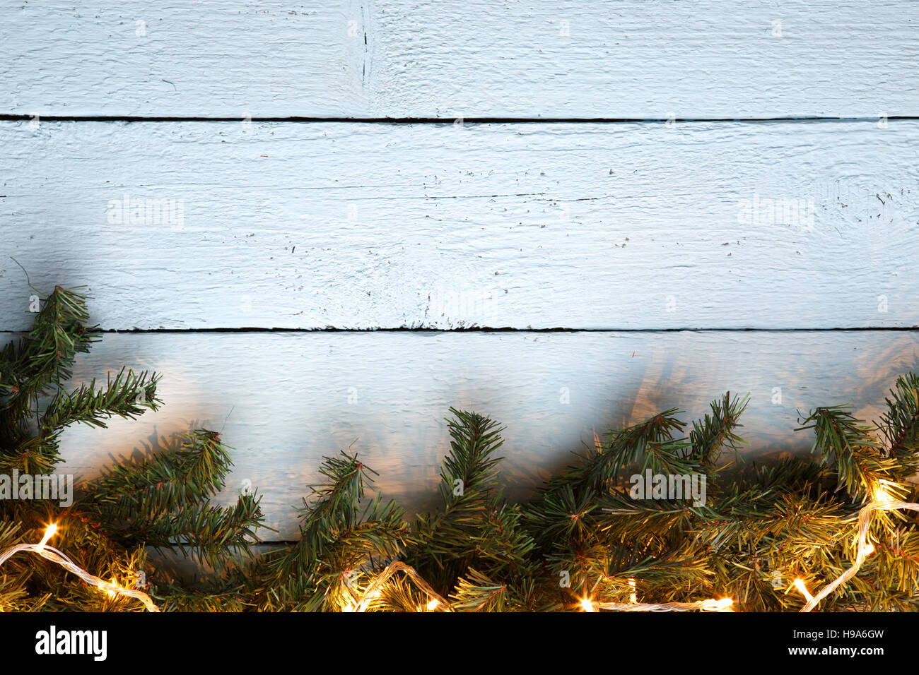 Wooden white texture background with christmas fir tree and lightbulb ...