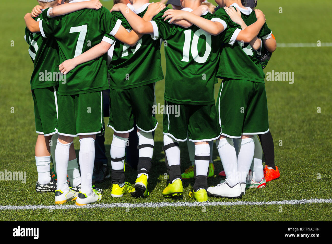 Sports team standing together on field. Football team motivated by ...