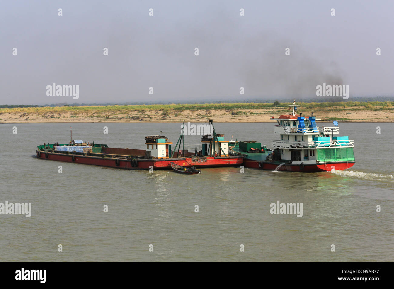 A river cargo boat heads upstream while pushing a barge on the ...