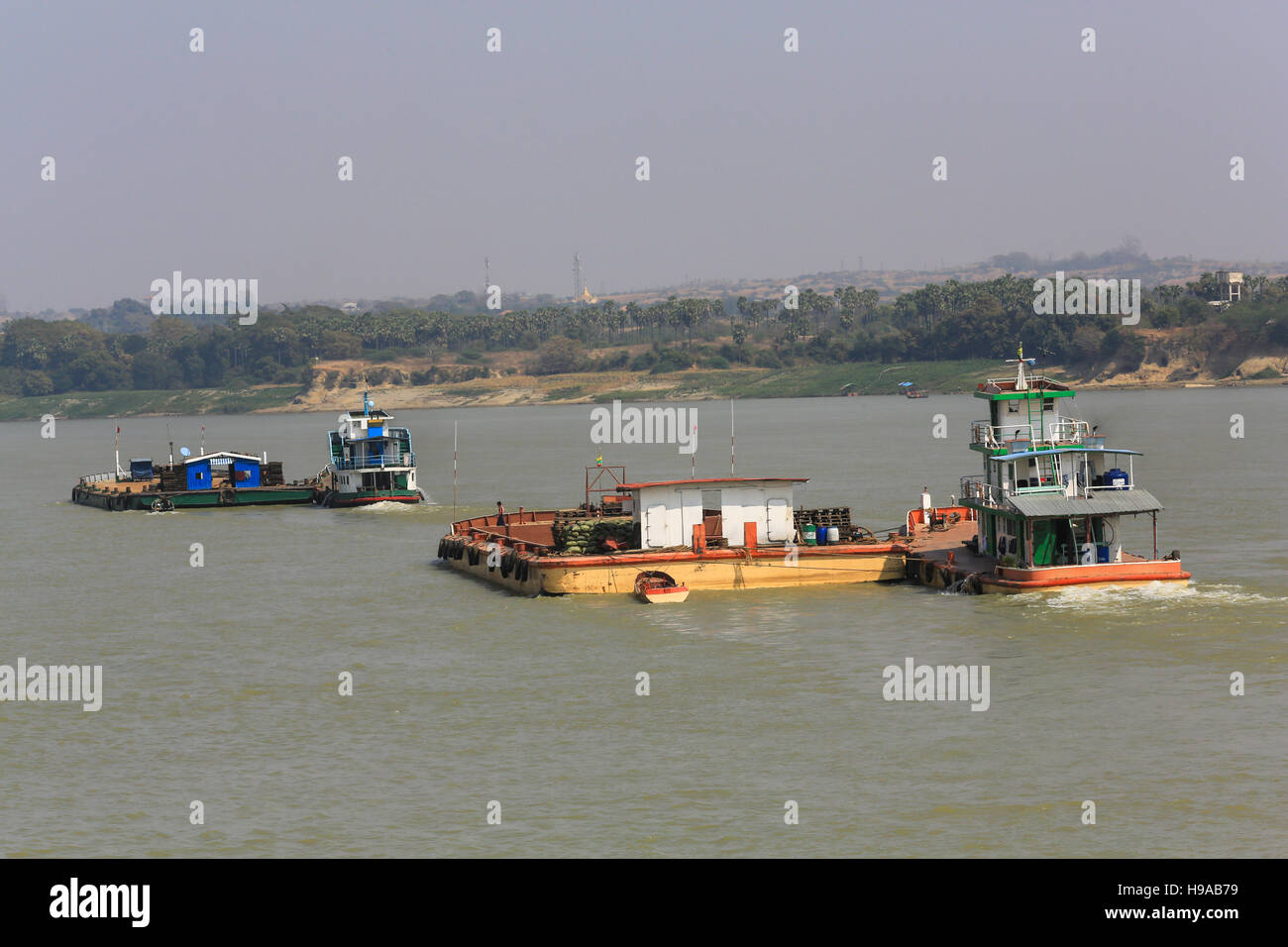 Two river cargo boats head upstream while pushing barges on the ...