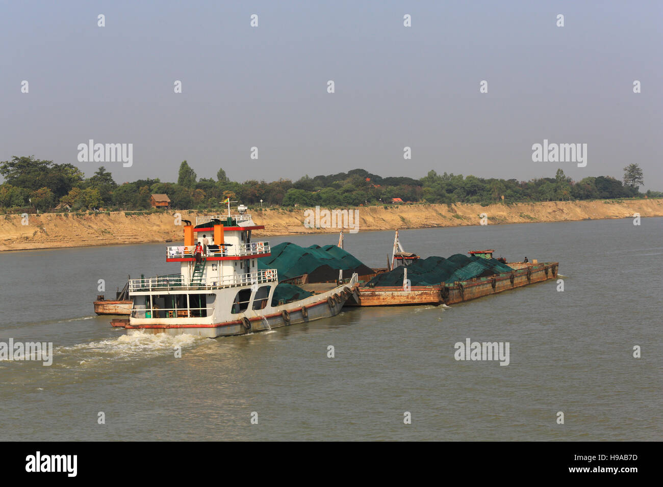 A river cargo boat heads upstream while pushing two barges on the ...