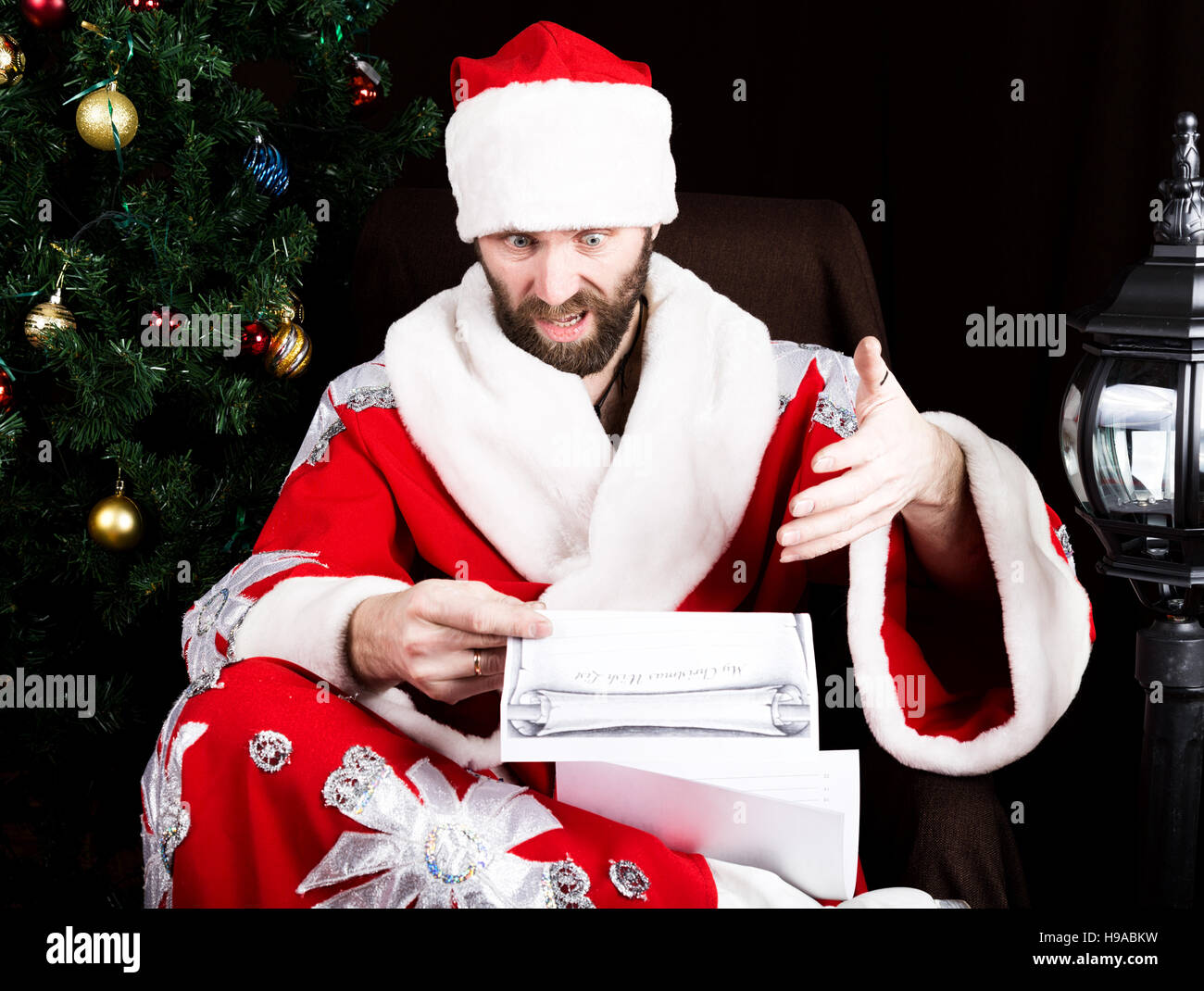 bad brutal Santa Claus discontentedly reads letter with the wishes, on ...